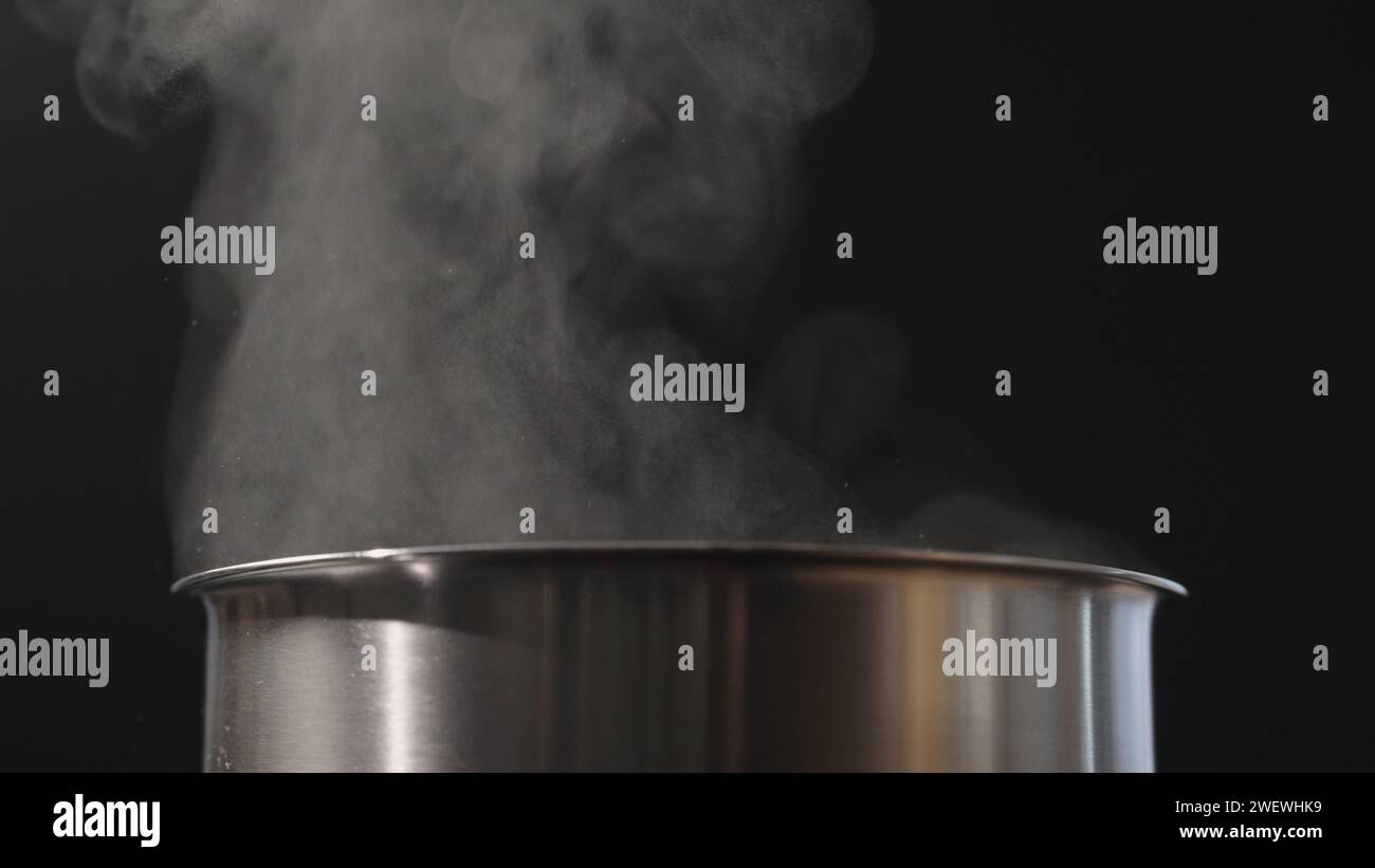 Steam rising from pot over black background, wide photo Stock Photo - Alamy