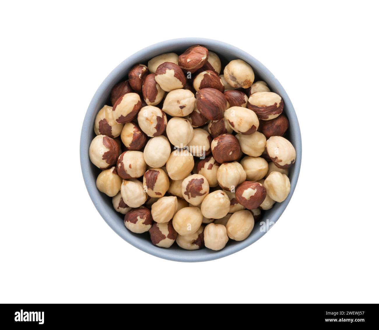 Top view of peeled hazelnuts in a blue bowl isolated on white ...
