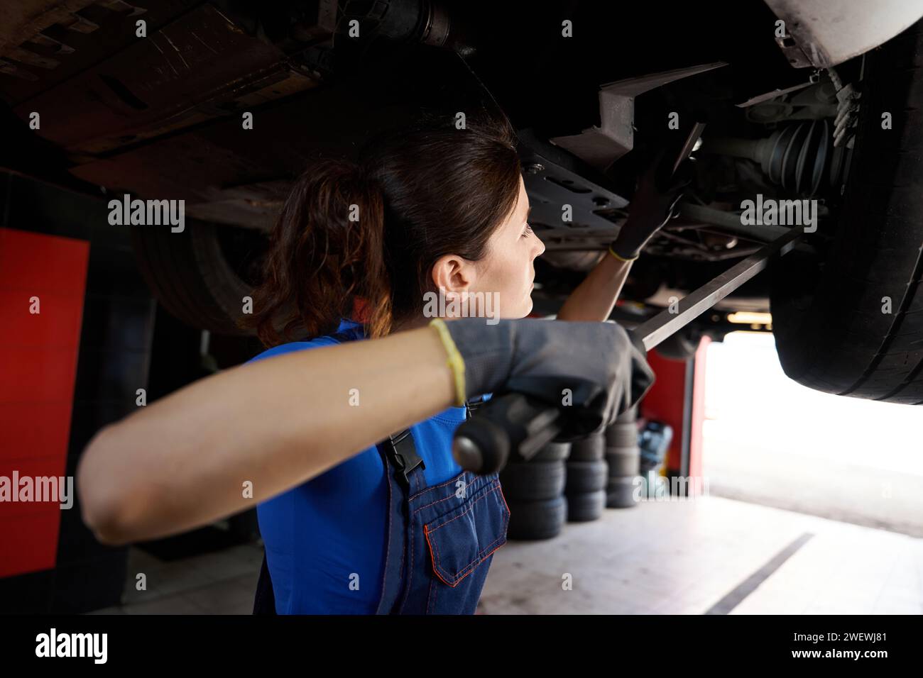 Female auto mechanic inspects the underbody of a car Stock Photo - Alamy