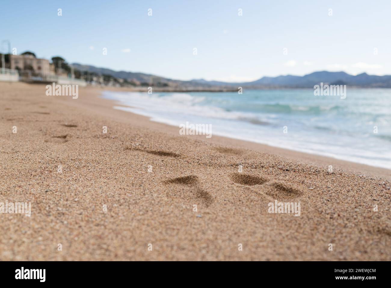 Footsteps on a sand beach of South France during spring with sea waves ...