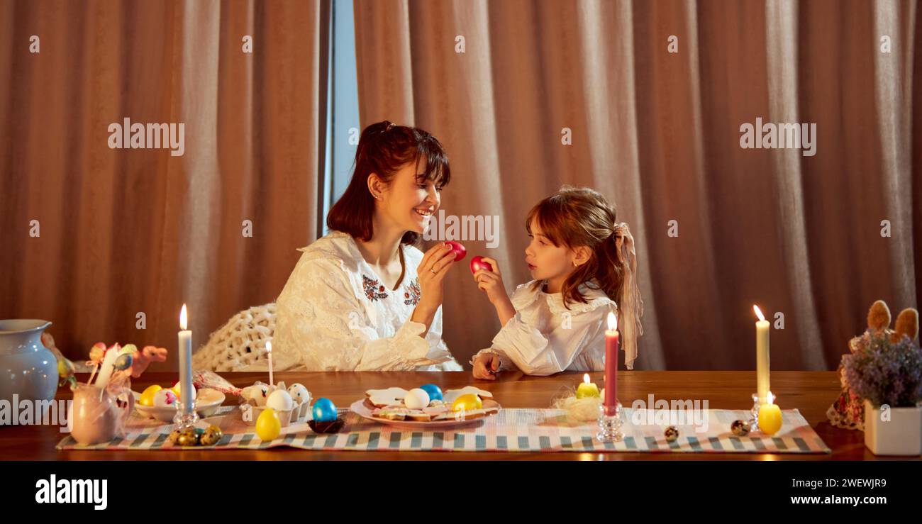 Cracking eggs for a good luck. Smiling happy mother and her little ...