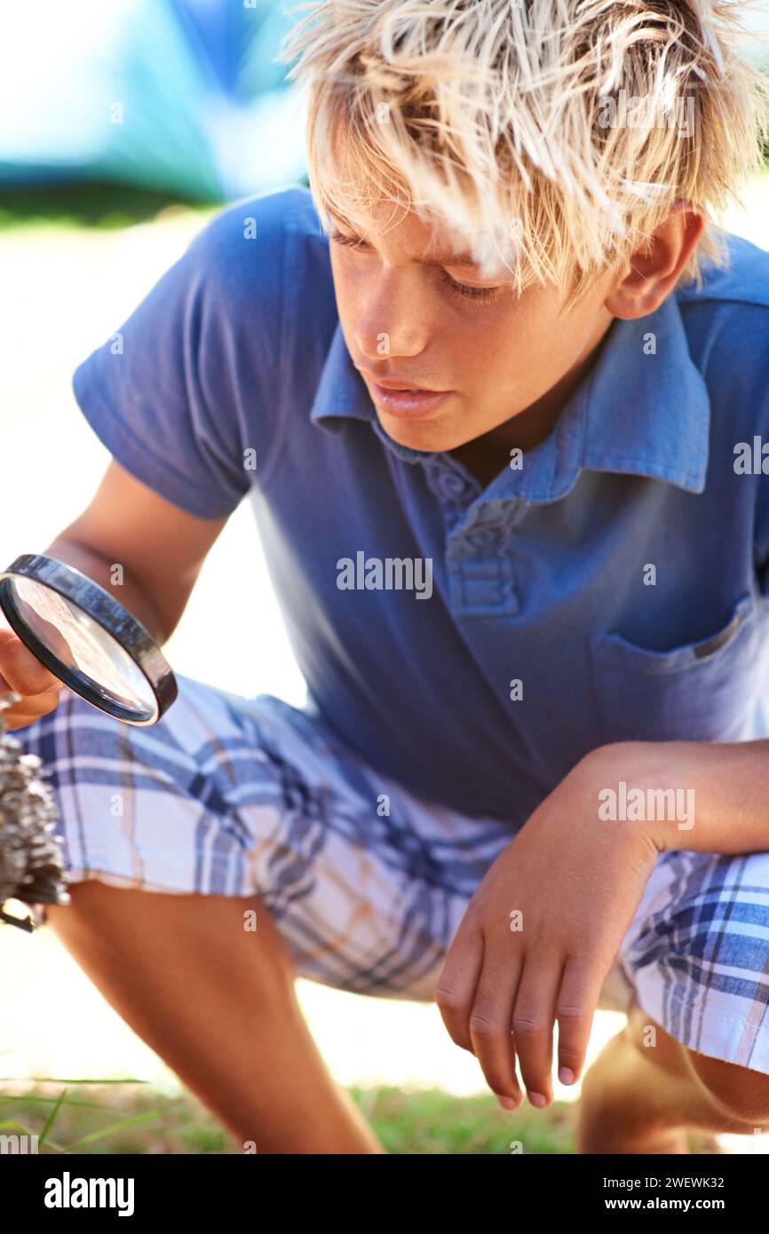 Magnifying glass, search and nature with curious boy outdoor in park ...