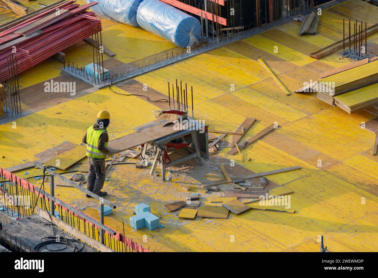 Construction worker saws boards for ceiling formwork with table saw ...