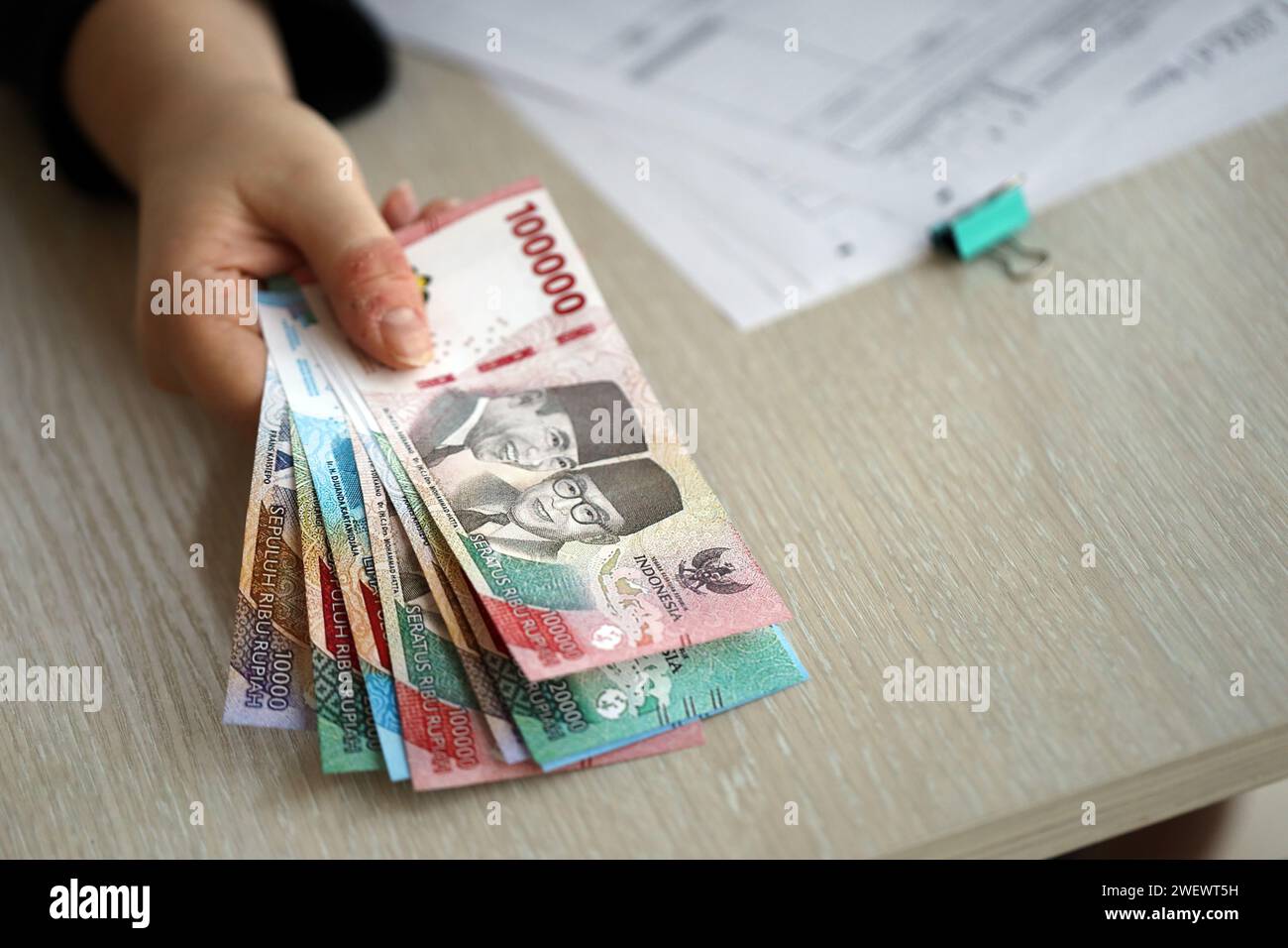 Female accountant hand give bunch of many indonesian rupiah money bills ...