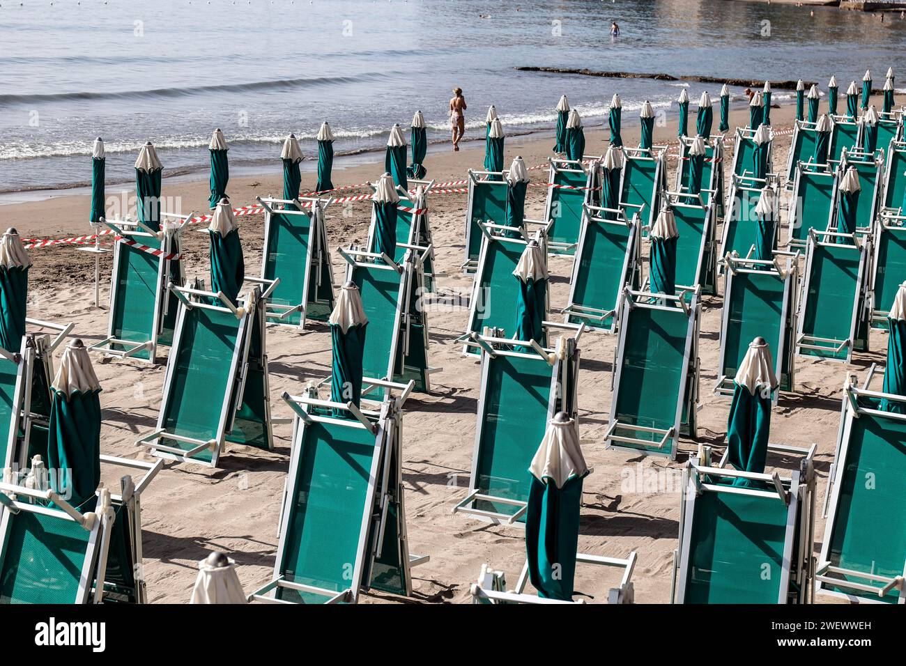 Beach loungers and parasols on the Italian Riviera on the beach at ...