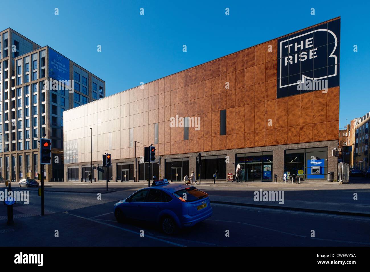 The Rise Redhill general view with blue sky and low sun reflecting of ...