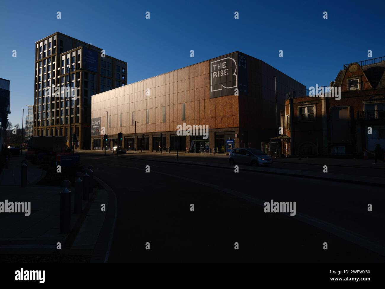 The Rise Redhill general view with blue sky and low sun reflecting of ...