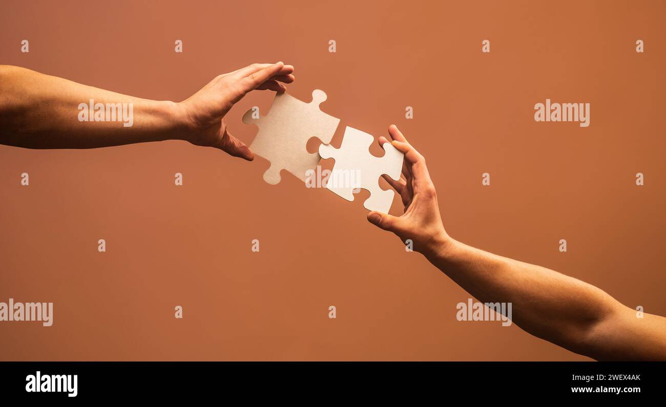 Two hands trying to connect couple puzzle piece on gray background ...