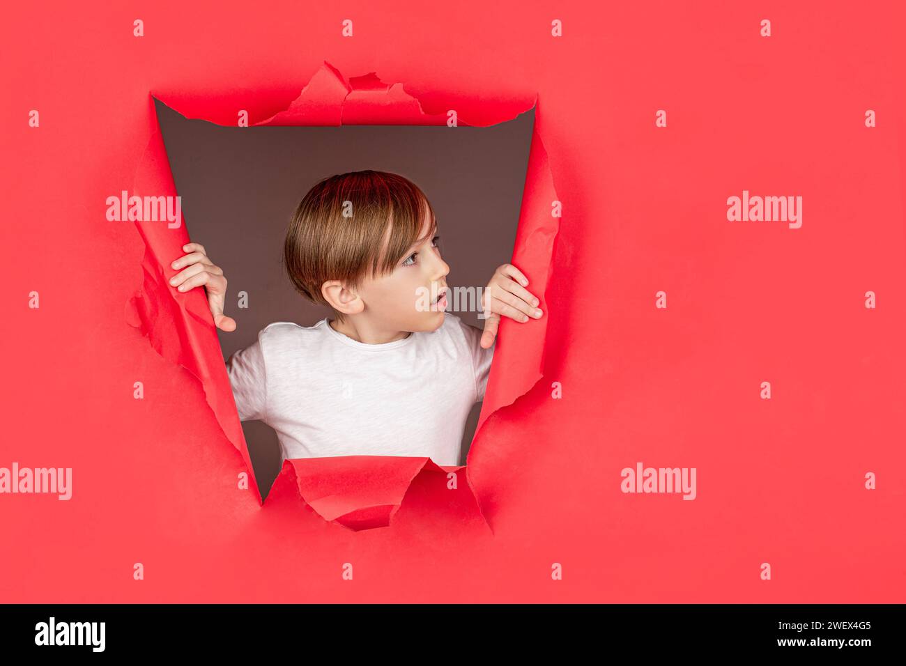 Breaking paper background. Kid shows face in paper hole. Positive child ...