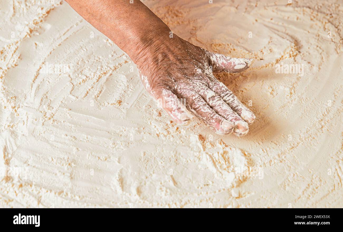 Dough on white powder covered table. Hand flour. Hands baker with flour ...
