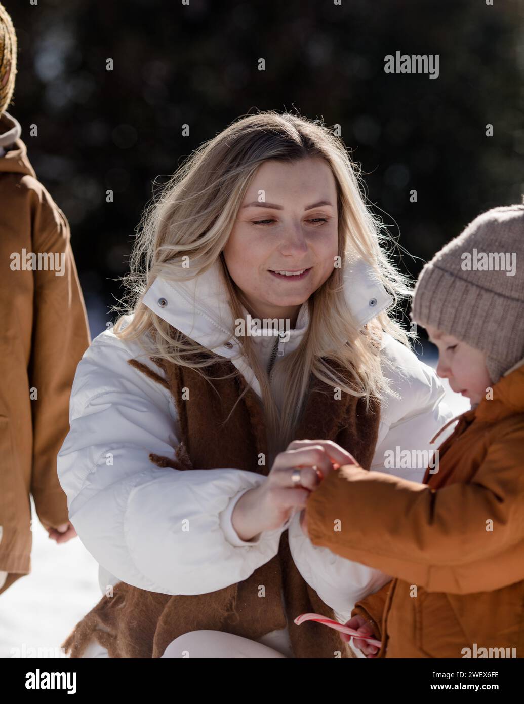 Winter weekend. Mother and two sons in warm winterwear walking while ...