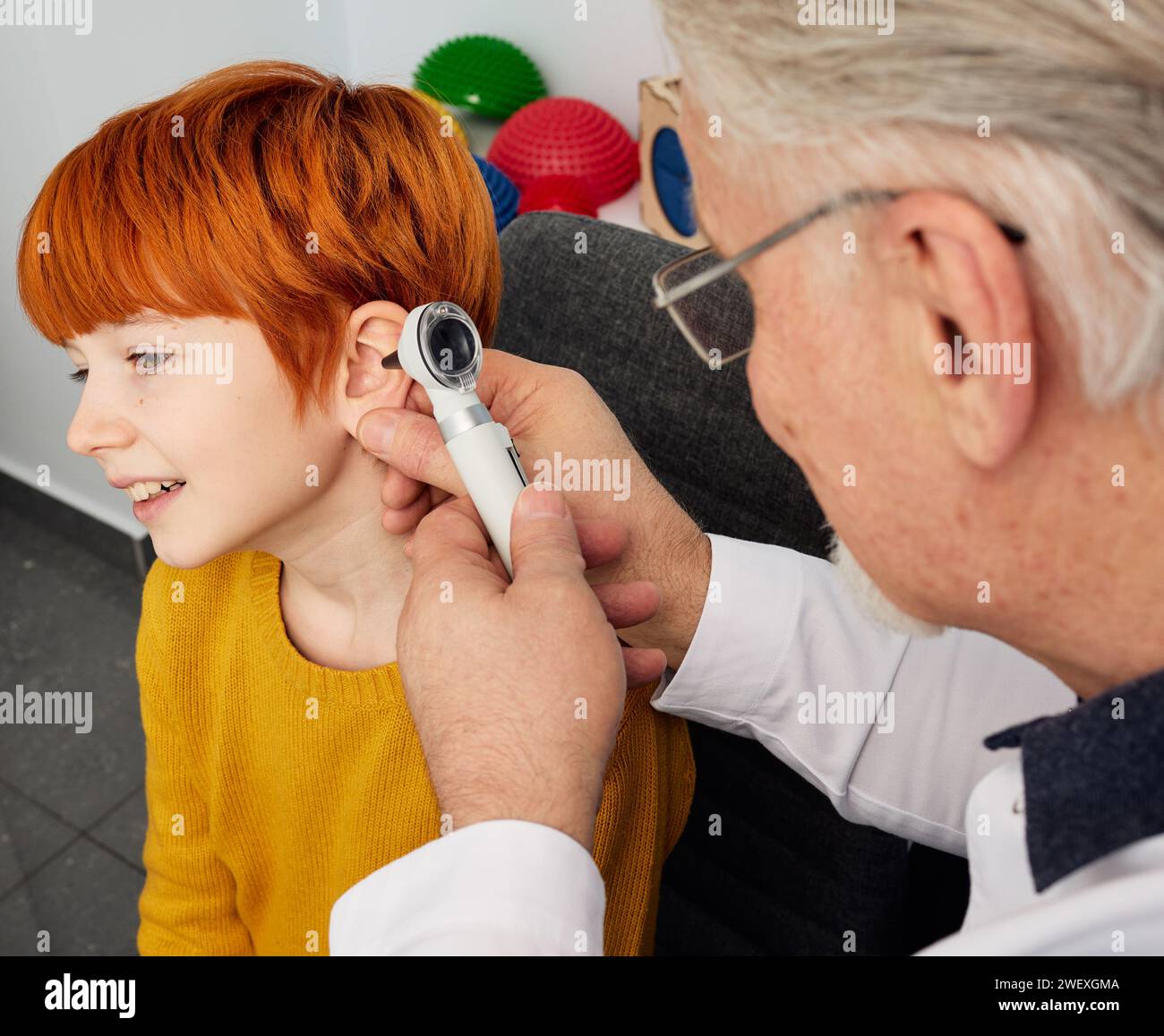 Otoscopy and hearing check-up for red-haired boy at audiology office of ...