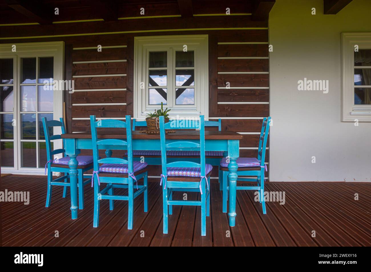 Bench, chairs and table on the terrace of the wooden house Stock Photo ...