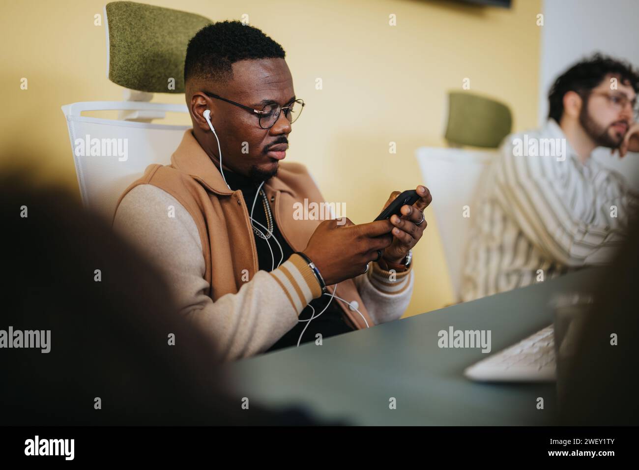 Male employee watching tutorial on his phone to solve a problem at his ...