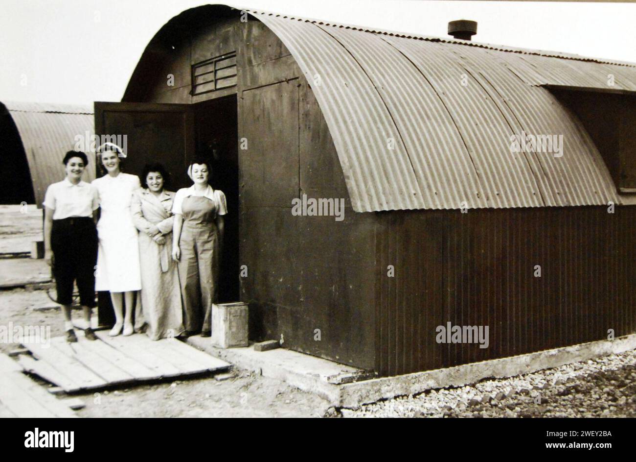 American nurses outside living quarters, a corrugated iron hut ...