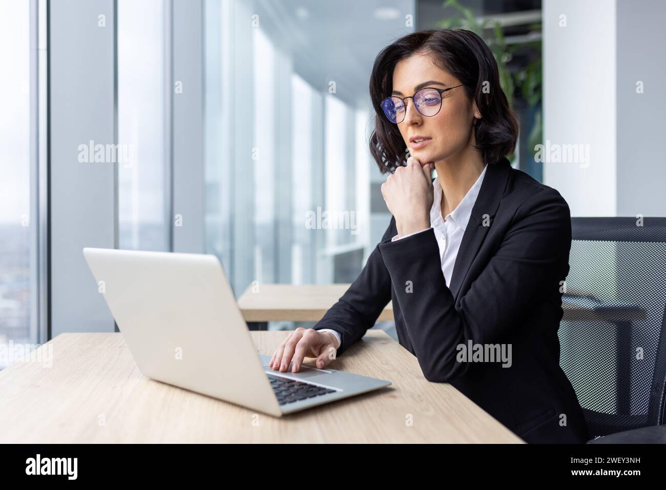 Serious businesswoman boss thinking working with laptop inside office ...