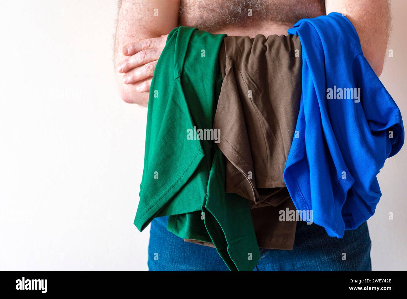 In the hands of several different t-shirts. man wearing t-shirt and ...