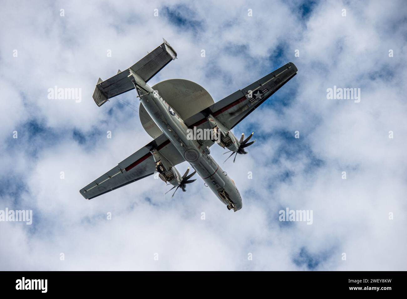 An E-2C Hawkeye flies over the aircraft carrier USS Nimitz during ...