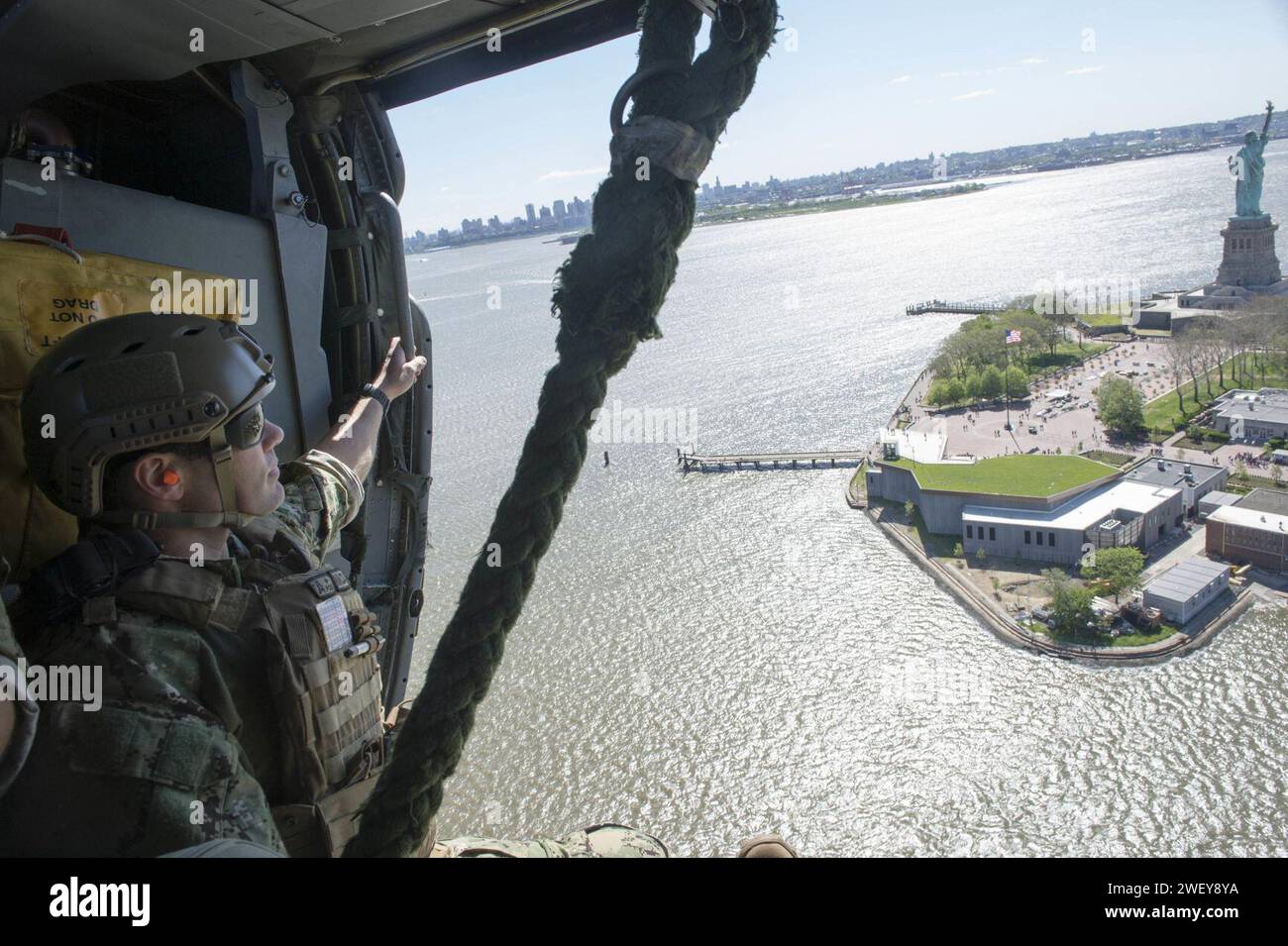 An EODMU 6 technician flies past the Statue of Liberty in an MH-60S ...