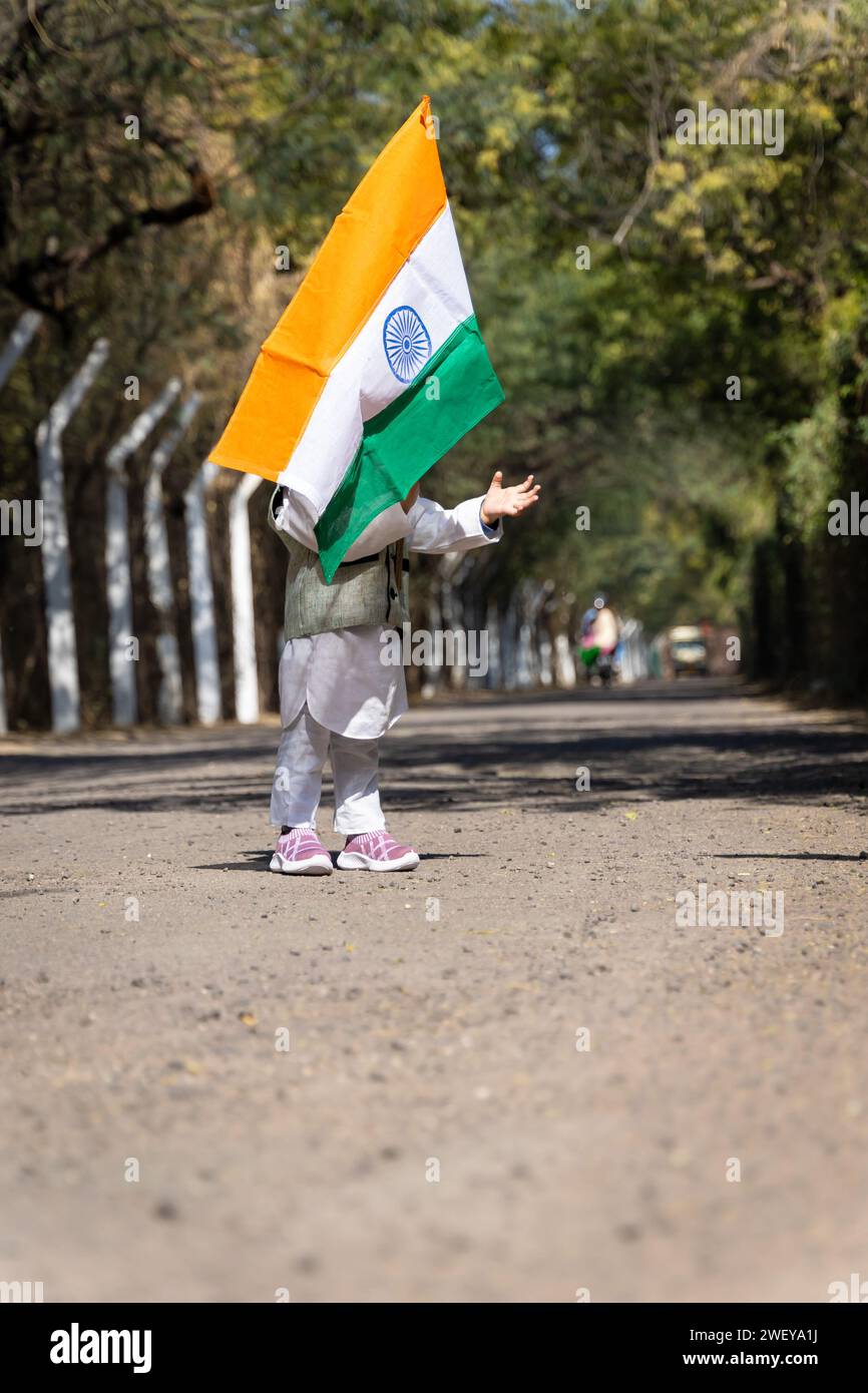 young kid waving the indian tricolor national flag at day from flat ...