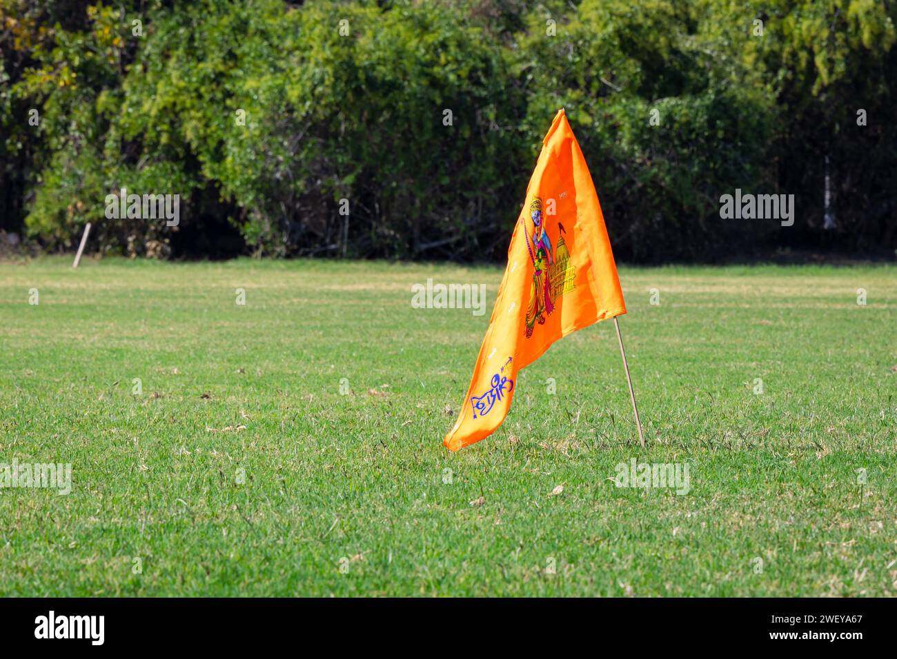 holy saffron flag with lord rama idol waving at ground with green tree ...