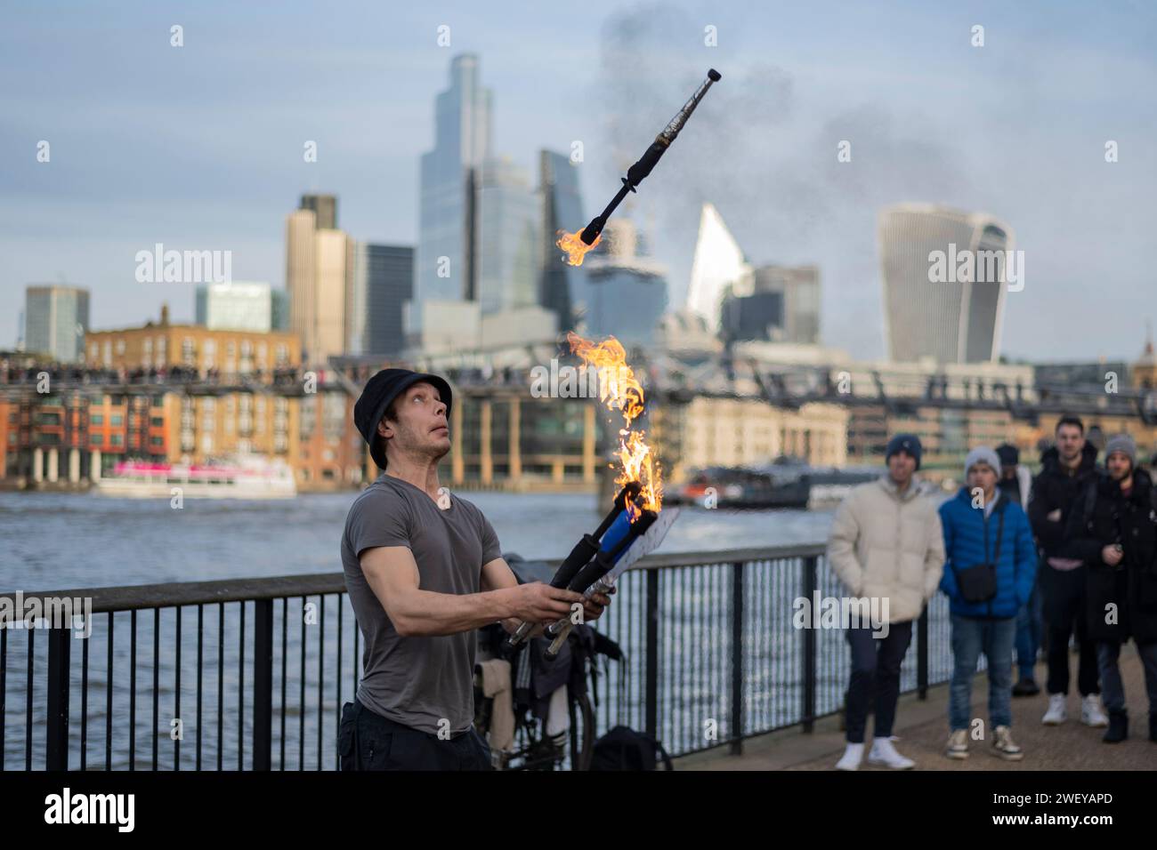 London, UK. 27 January 2024. A street performer juggles with fire ...