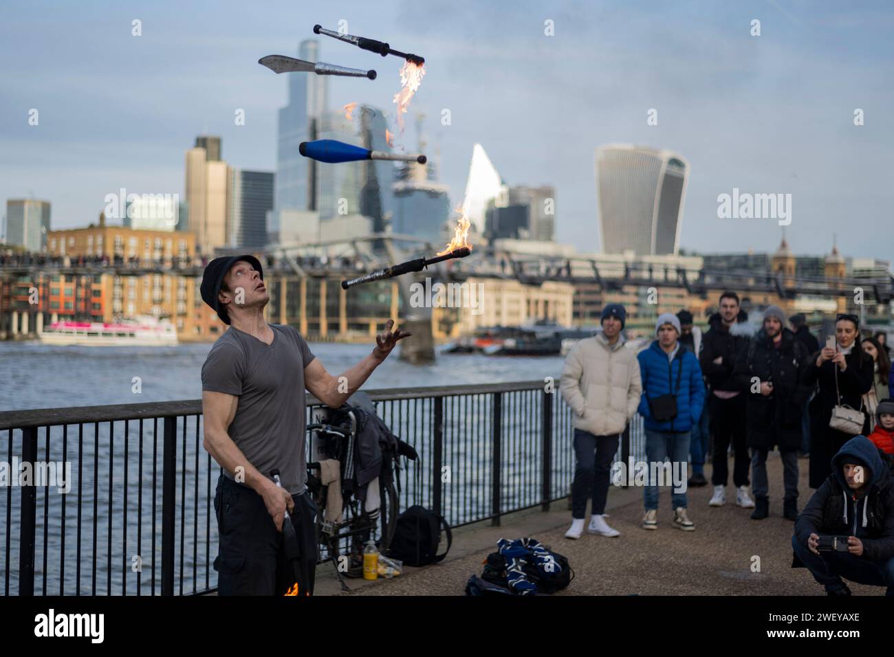 London, UK. 27 January 2024. A street performer juggles with fire ...