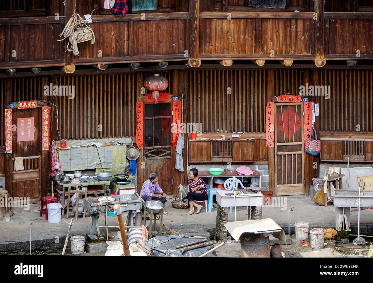 open air cooking in the courtyard of a Tulou (building made of rammed ...