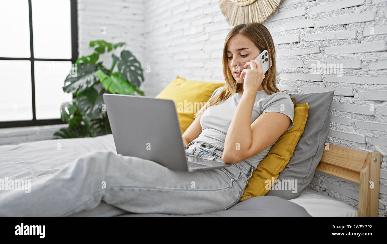 Beautiful young blonde woman seriously concentrating, talking on ...