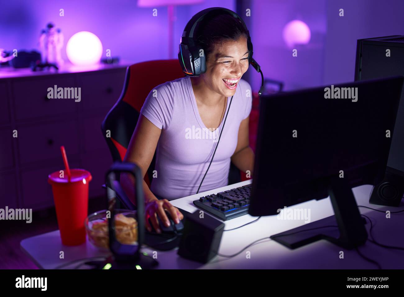 Young beautiful hispanic woman streamer playing video game using ...