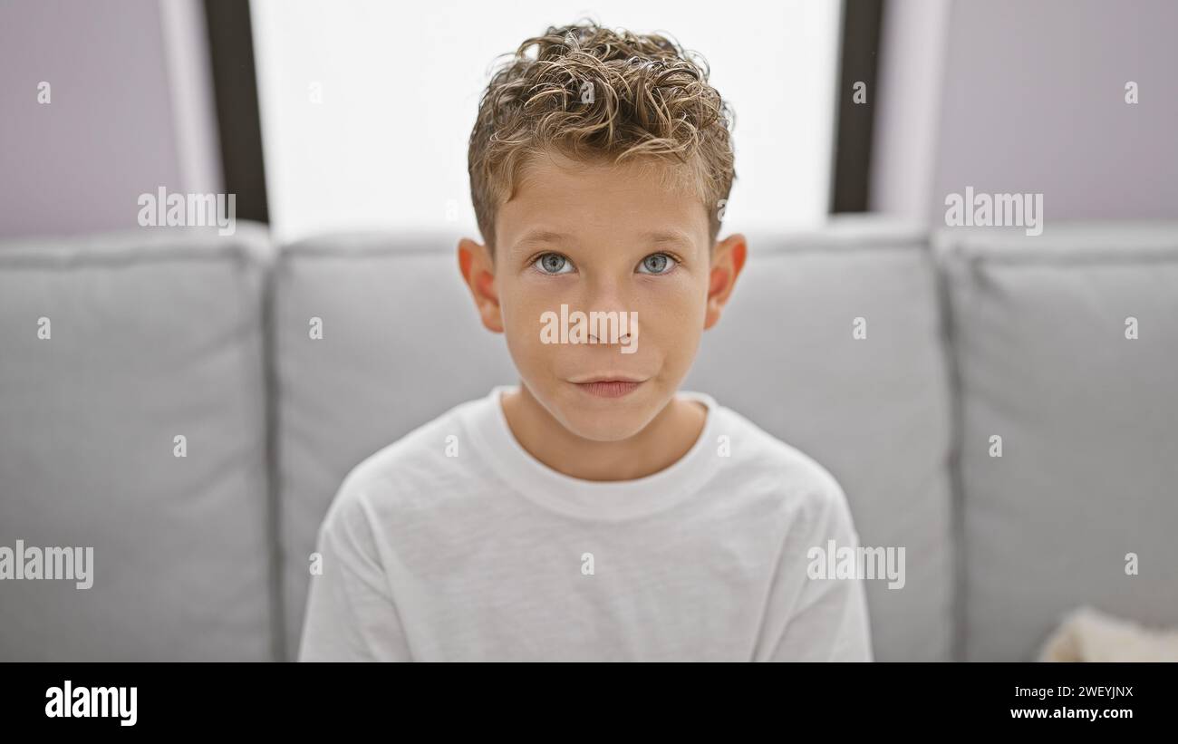 Adorable blond boy resting in a comfortable cozy living room ...