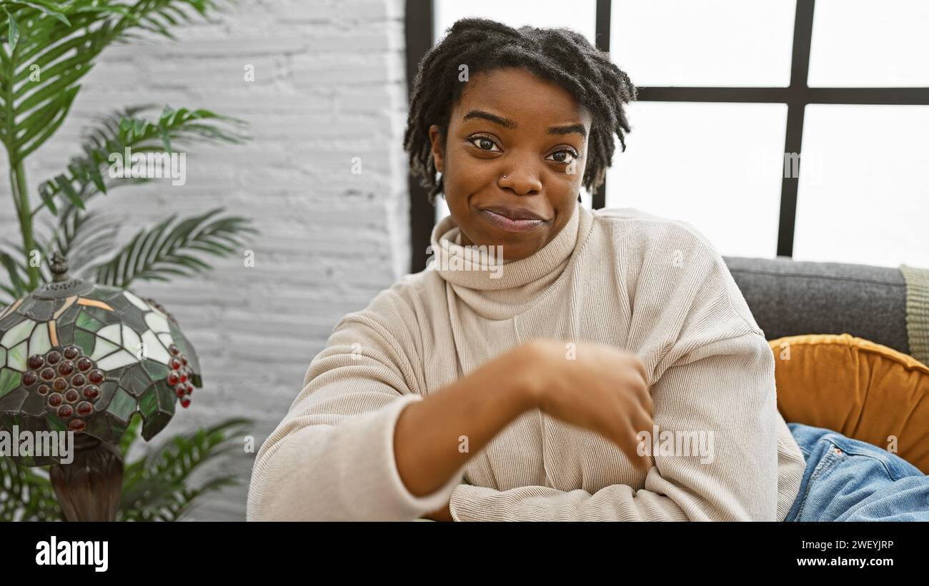 African american woman with dreadlocks wearing a sweater relaxes on a ...