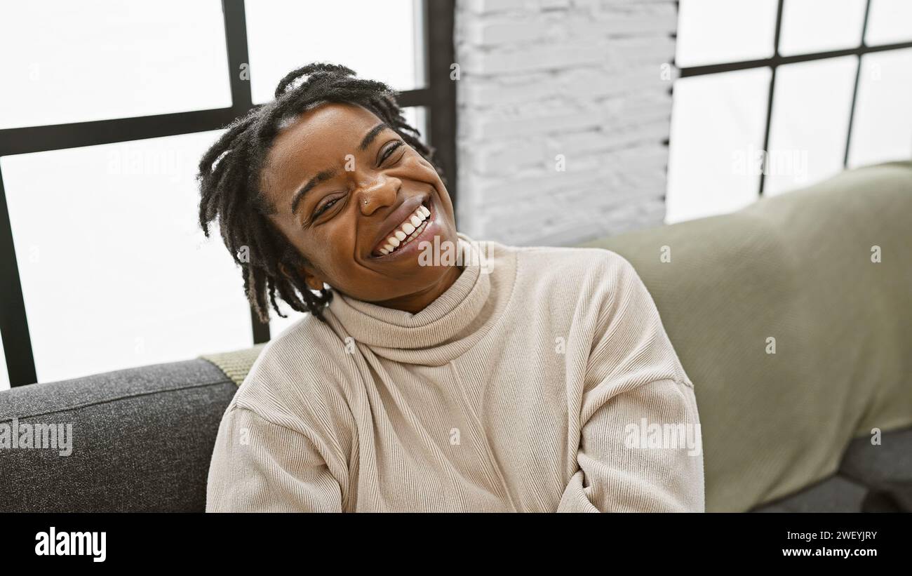 Joyful african american woman with dreadlocks wearing a sweater ...
