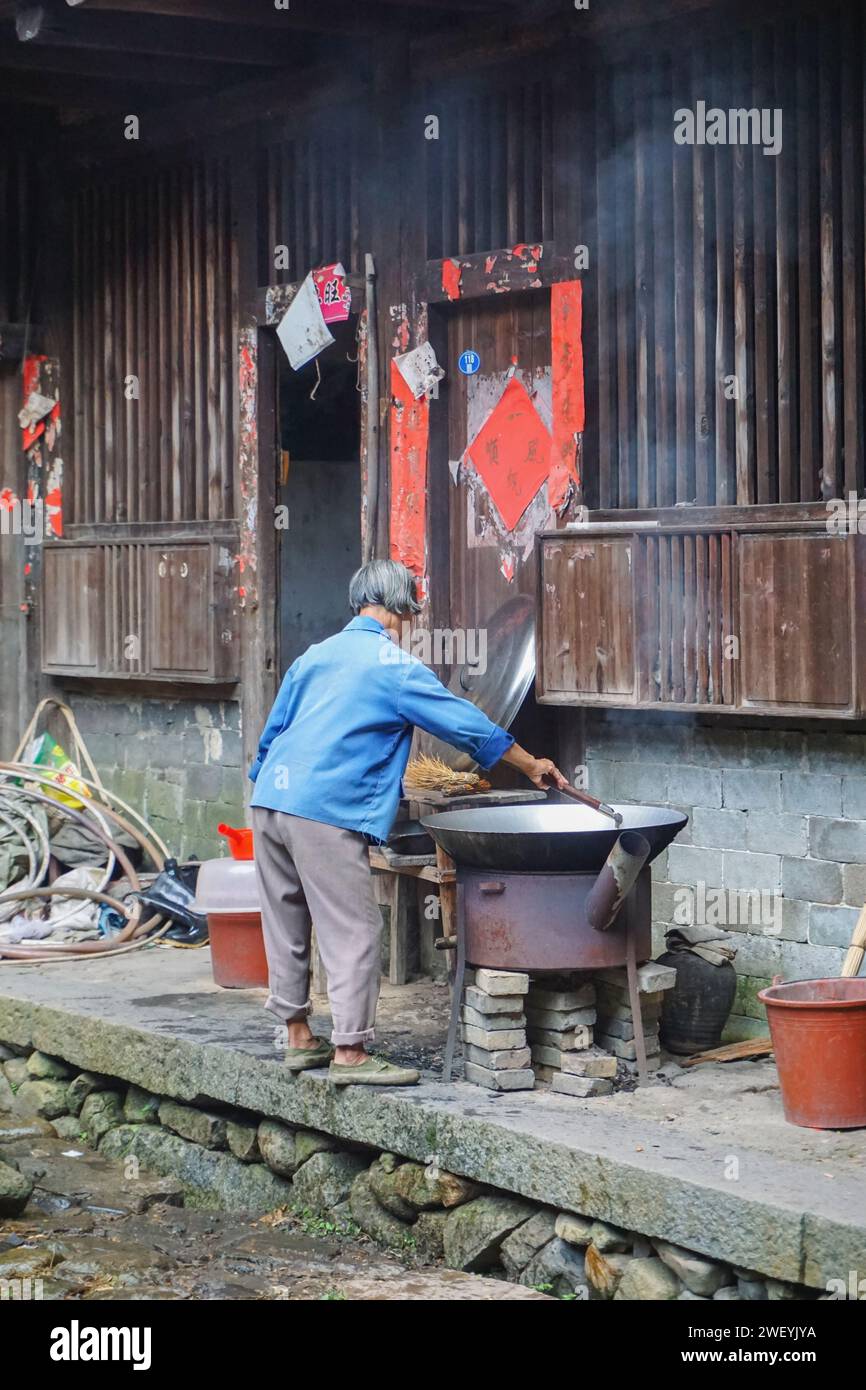 open air cooking in the courtyard of a Hakka Tulou (building made of ...