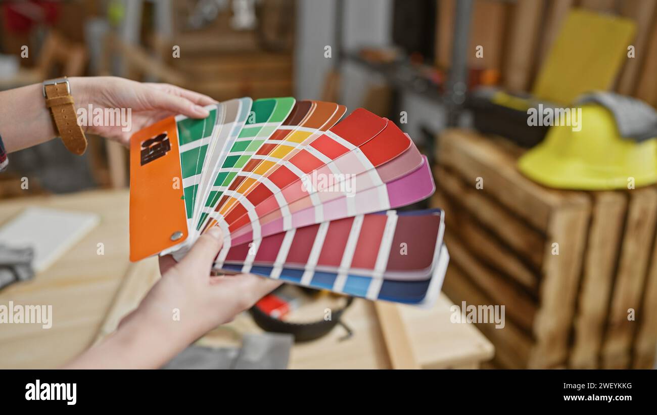 Woman holds color swatches in a carpentry workshop, indicating diy ...