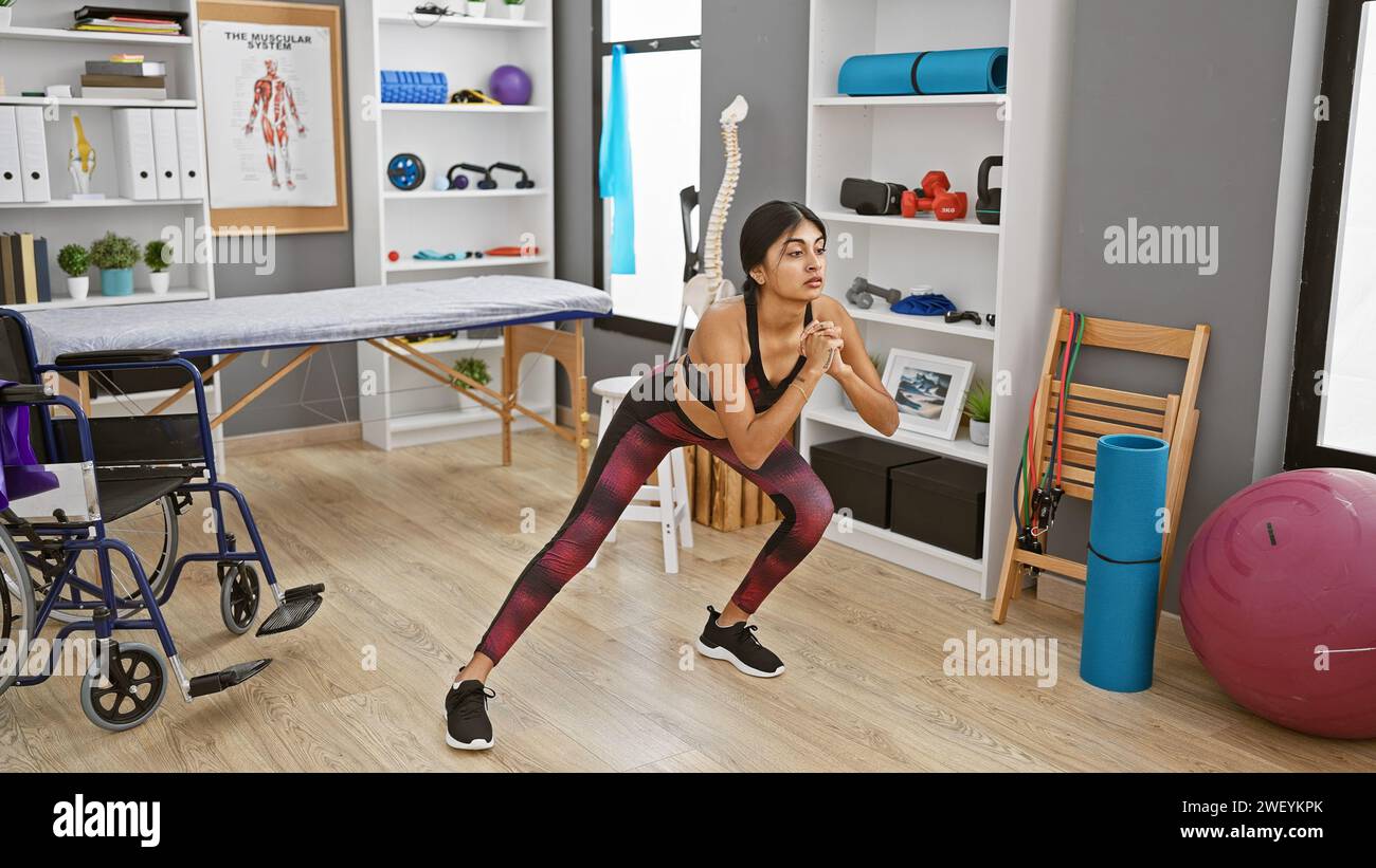 South asian woman in activewear exercises in a modern rehab clinic's ...