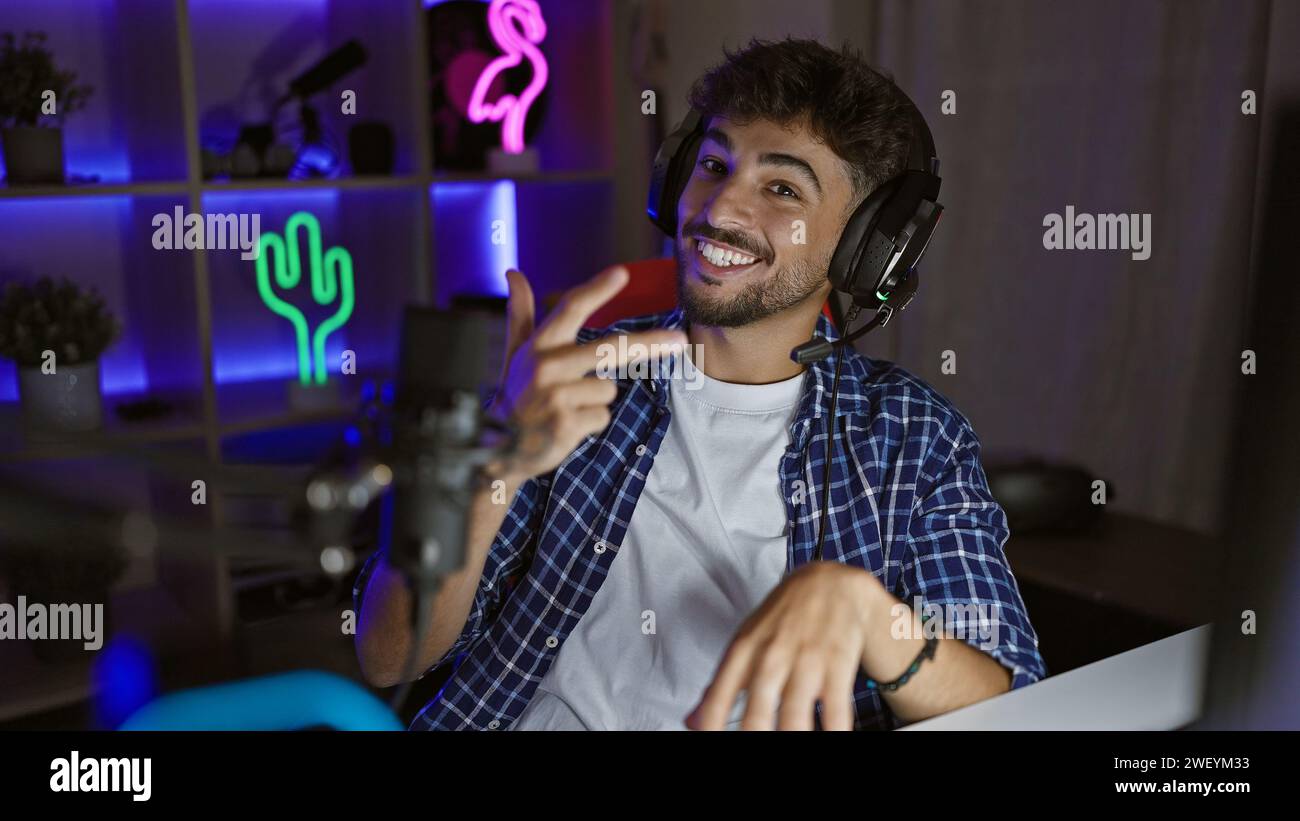 Young arab man, smiling streamer speaking during night time video call ...
