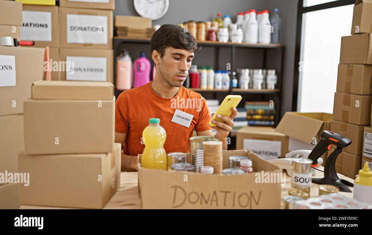 Dedicated young hispanic man volunteer earnestly checking charity ...