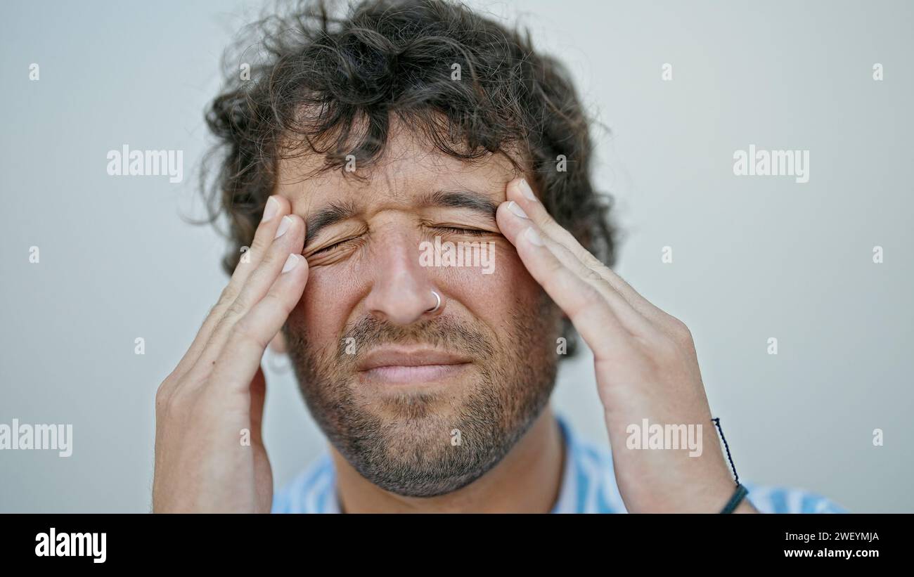 Young hispanic man suffering for headache over isolated white ...