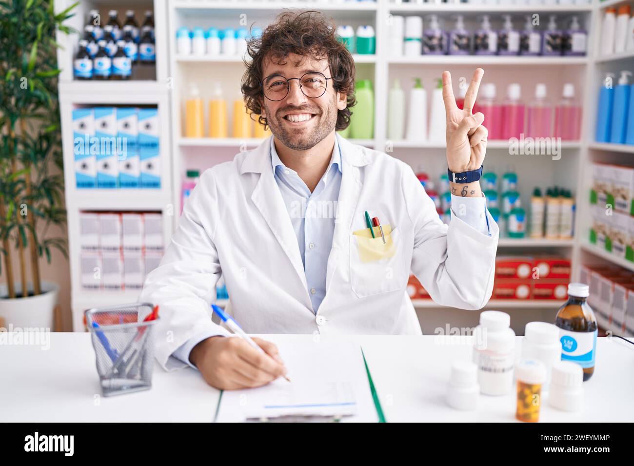 Hispanic young man working at pharmacy drugstore smiling with happy ...