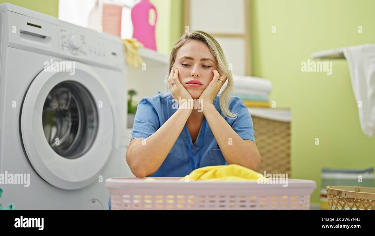 Young blonde woman professional cleaner tired leaning on basket with ...