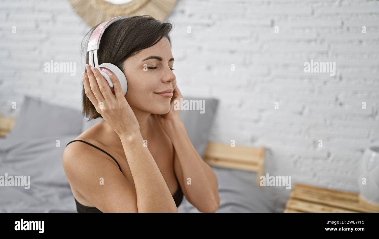 Radiant young hispanic lady in comfy pajamas enjoying her morning ...