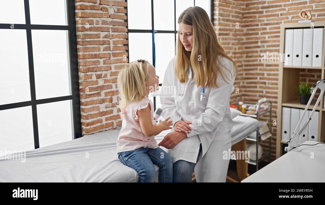 Caring pediatric doctor and adorable little girl patient playfully ...