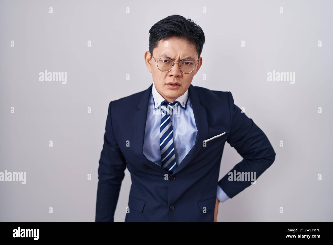 Young asian man wearing business suit and tie in shock face, looking ...