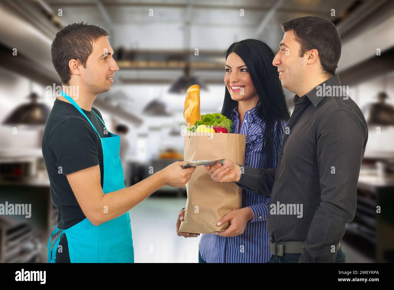 The couple expresses satisfaction as they pay a young cook in a ...
