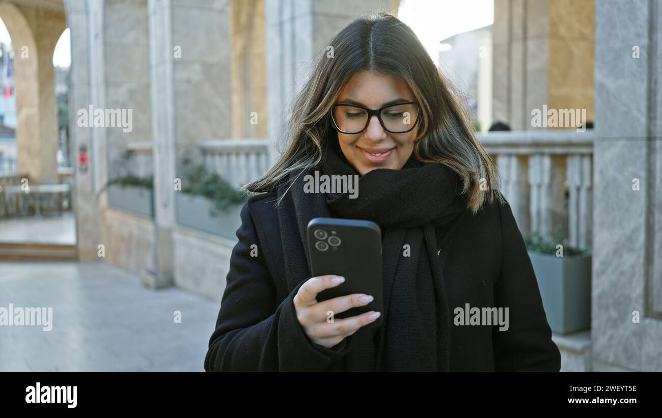 A smiling young woman checks her smartphone on an istanbul street ... A smiling young woman checks her smartphone on an istanbul street ...