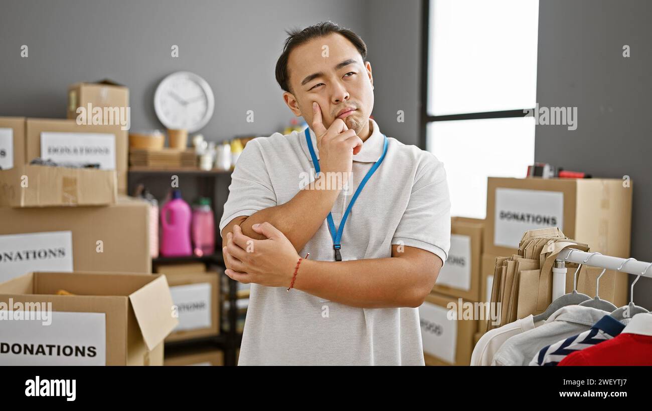 Handsome young chinese man volunteering, his serious face displaying ...