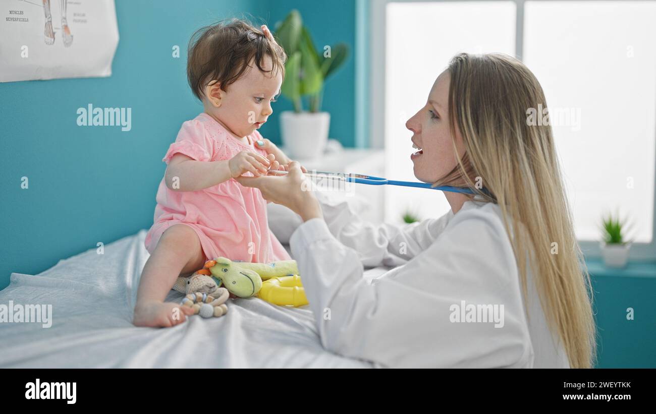 Mother and daughter pediatrician examining baby chest at clinic Stock ...