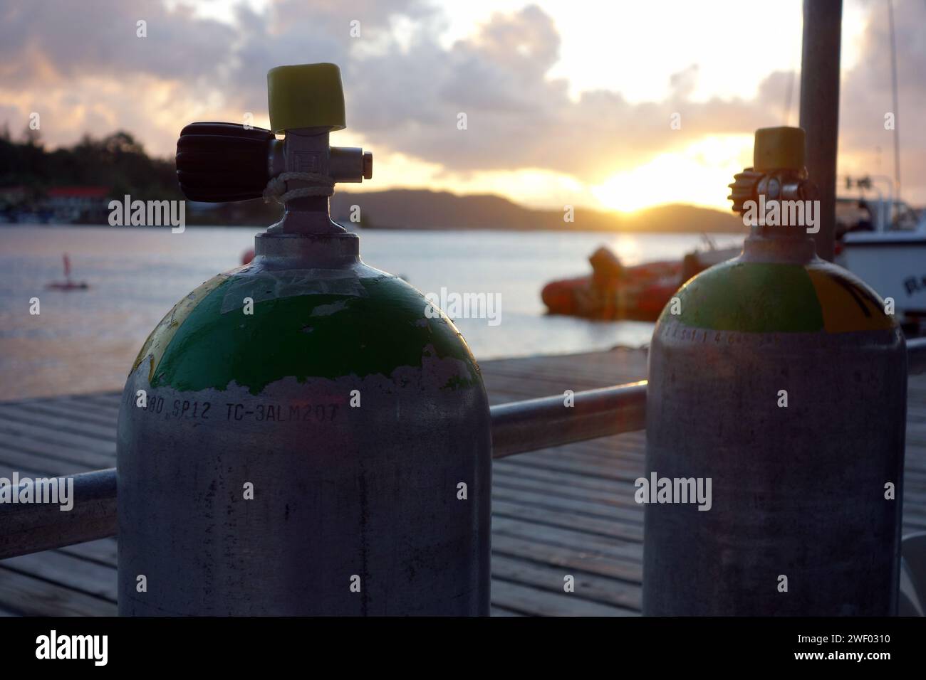 Close up picture of scubatanks with the ocean and boats in the backroud ...