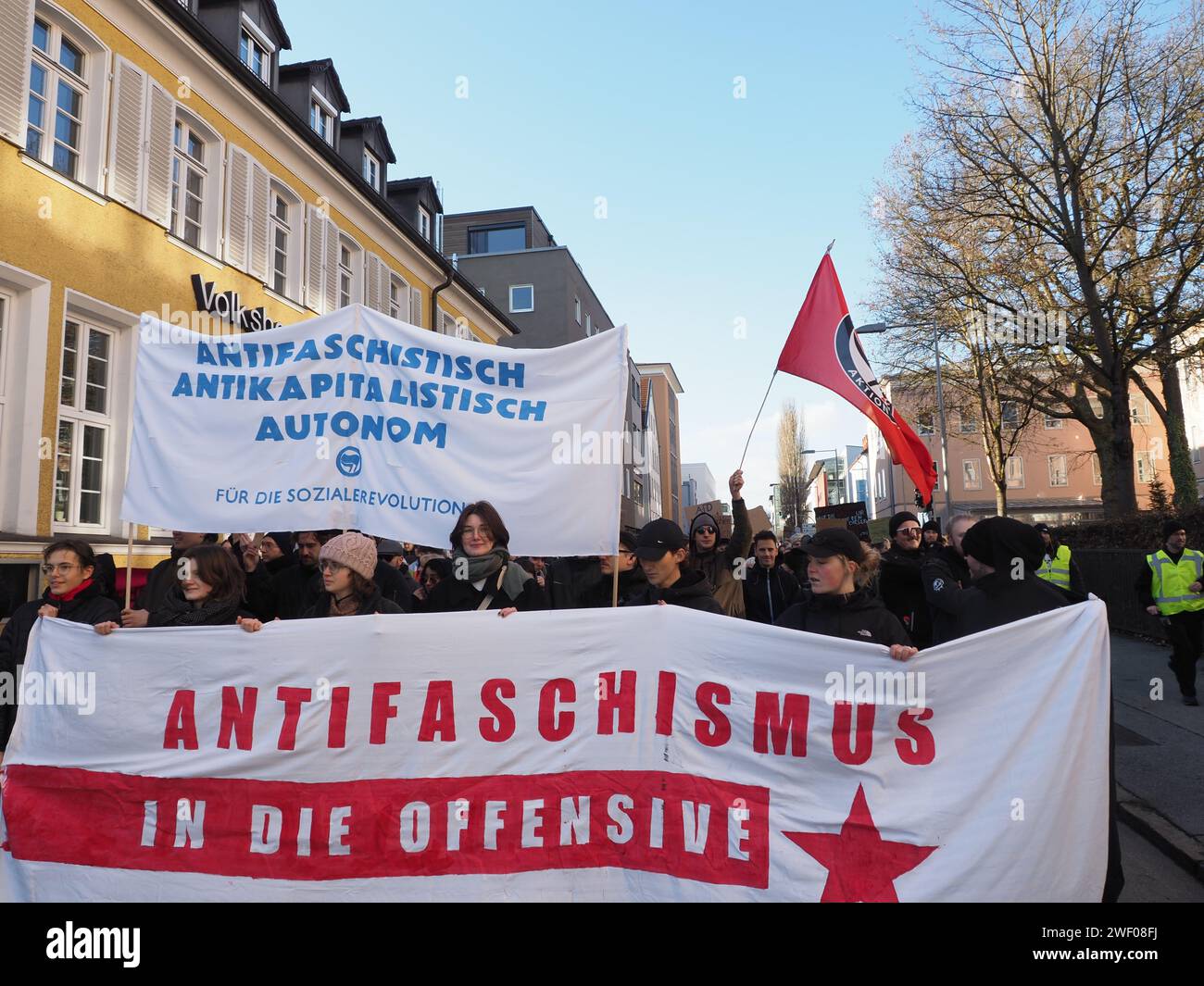 Young people with a banner “Anti-fascism in action” lead a column of ...